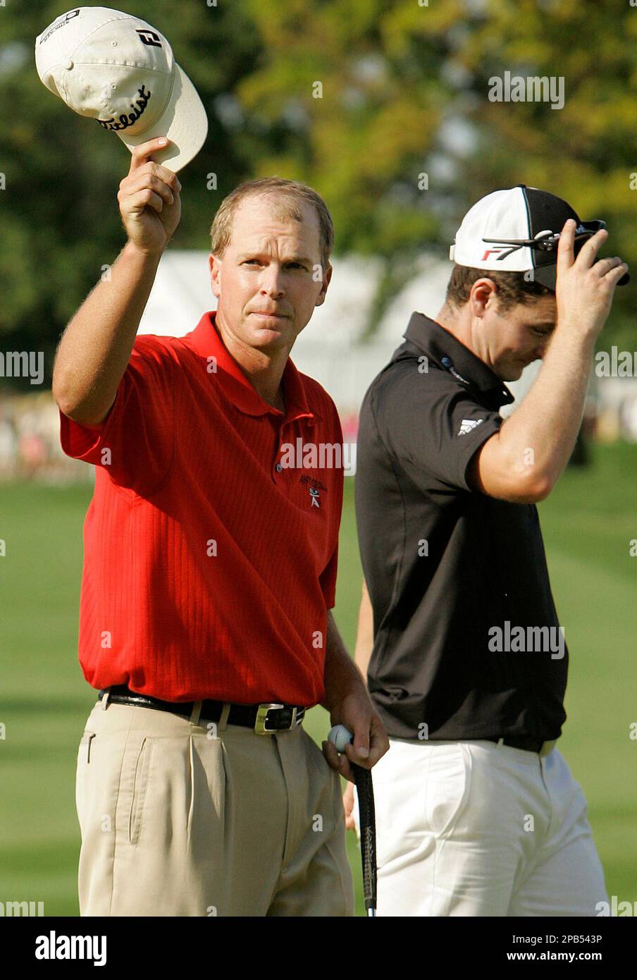 Steve Stricker, left, waves to crowd as Justin Rose looks down on the ...