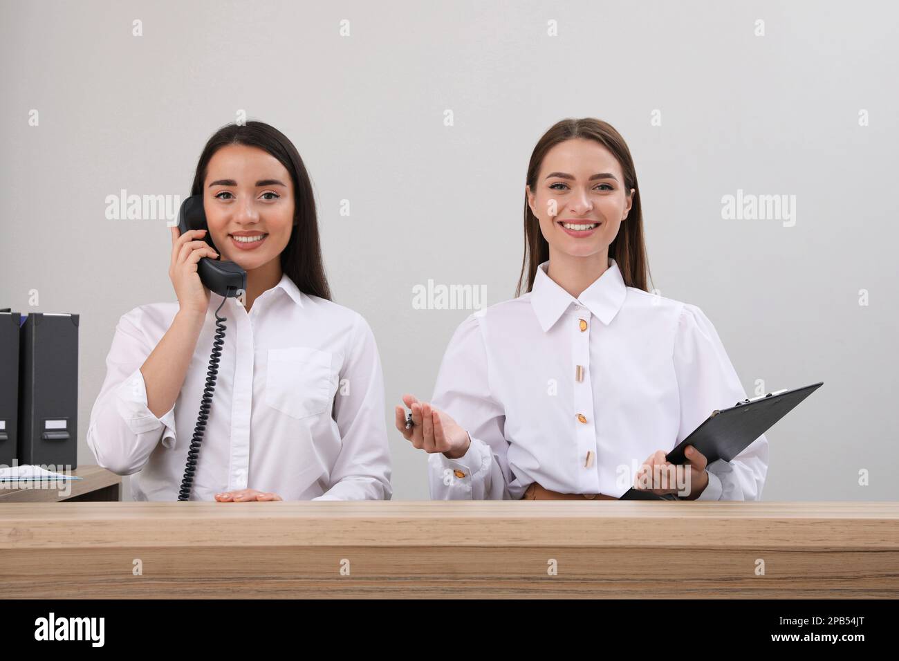 Female receptionists working at desk in hotel Stock Photo - Alamy