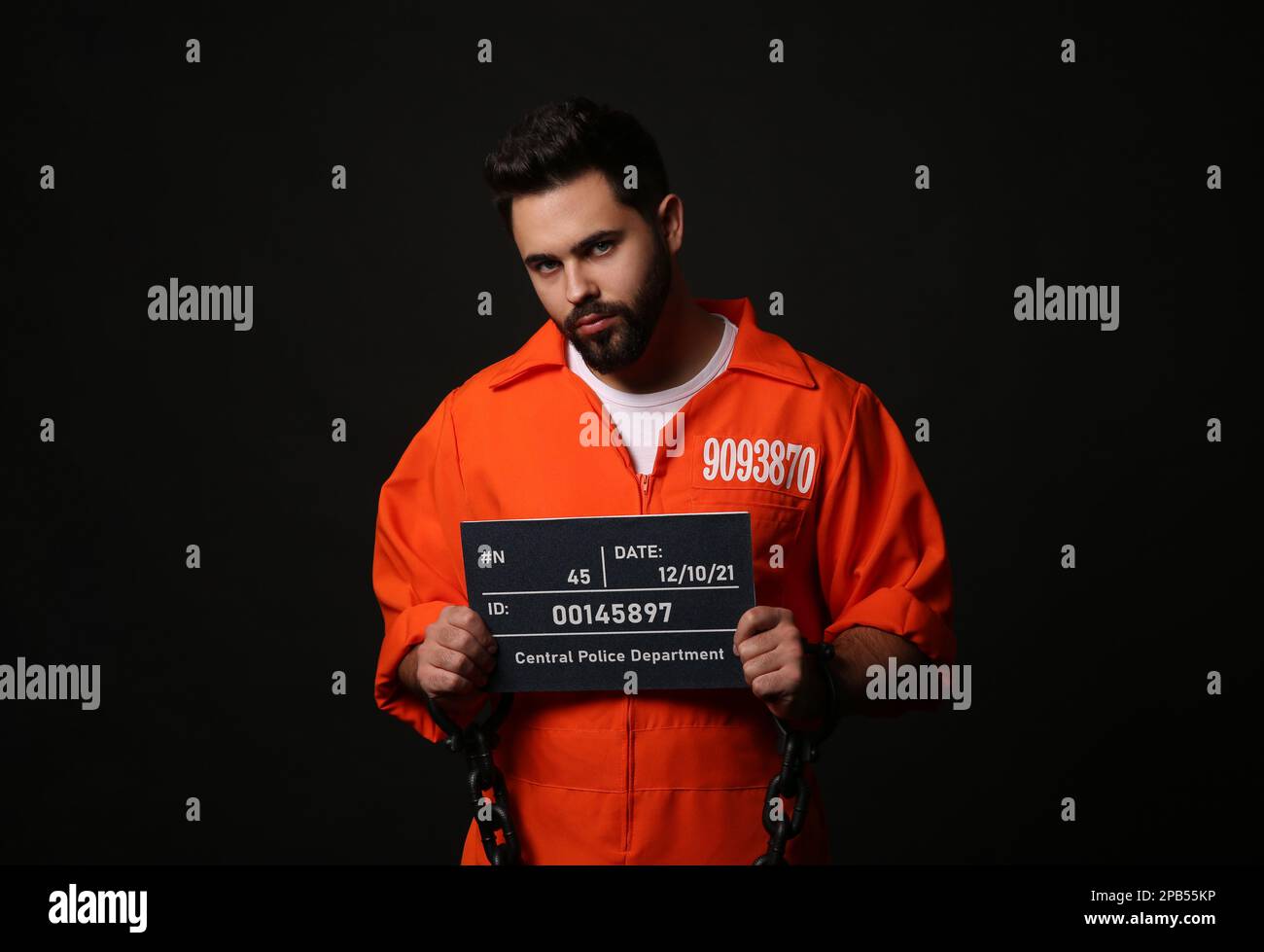 Prisoner with chained hands holding mugshot letter board on black ... Prisoner with chained hands holding mugshot letter board on black ...