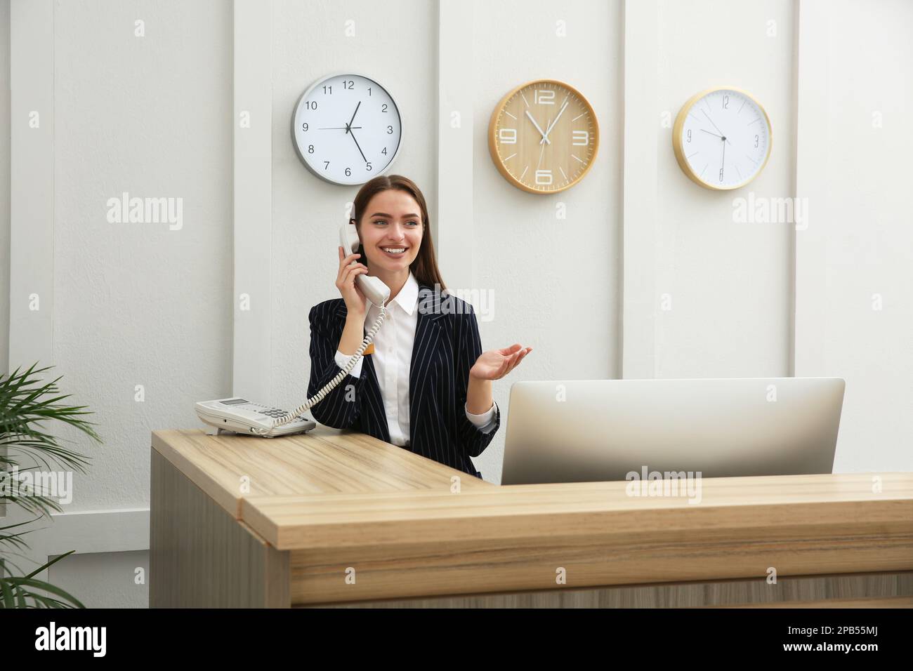 Beautiful receptionist talking on phone at counter in hotel Stock Photo ...