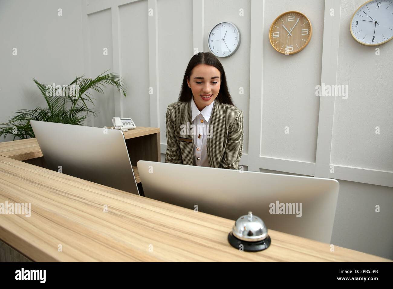 Beautiful receptionist working at counter in hotel Stock Photo - Alamy