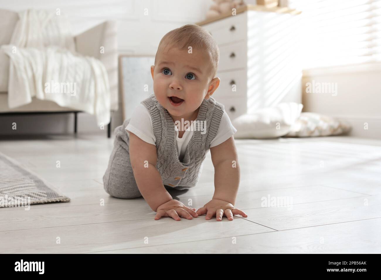 Cute baby crawling on floor at home Stock Photo - Alamy