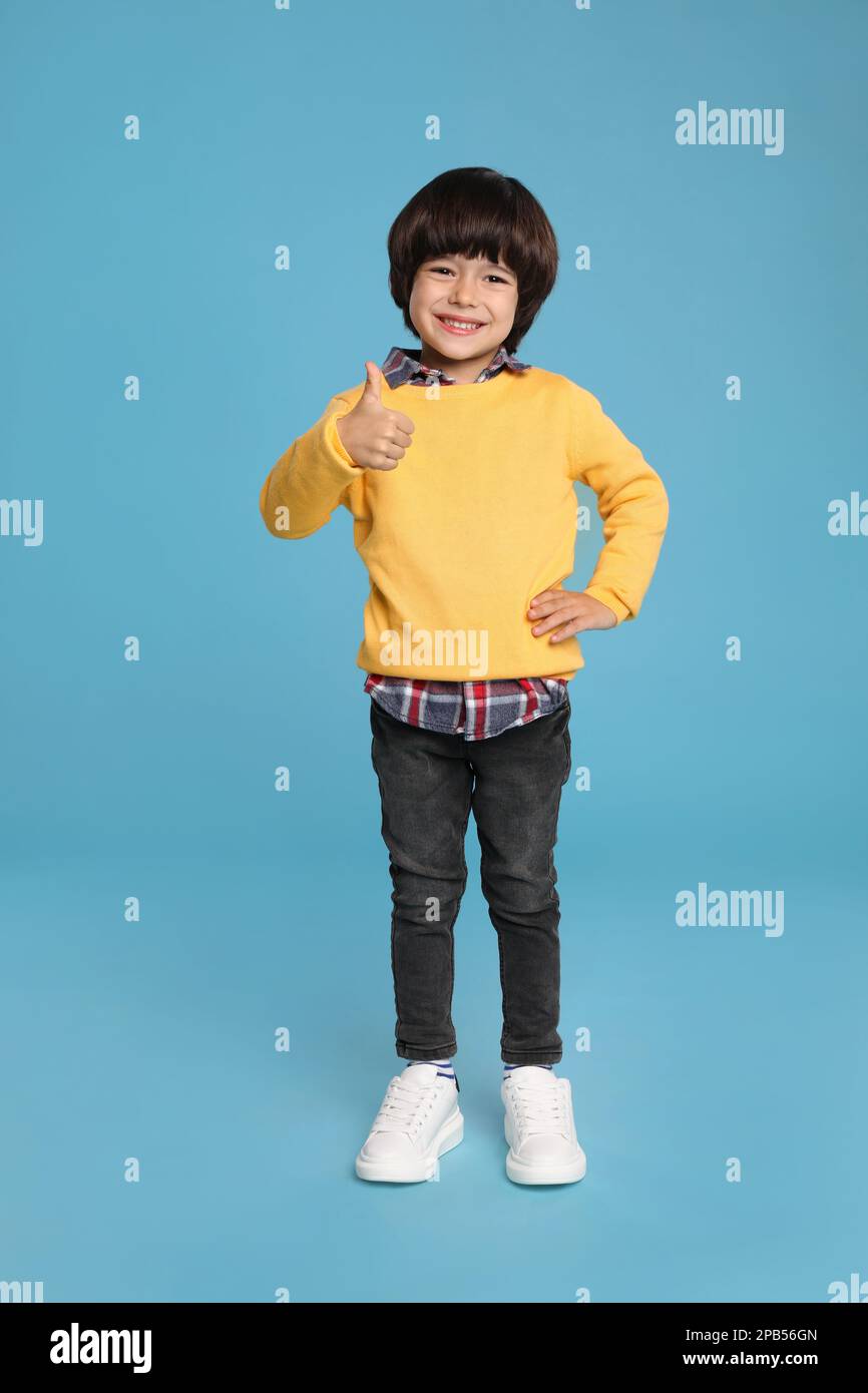 Full length portrait of cute little boy on light blue background Stock ...