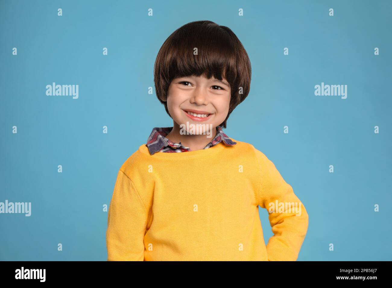 Portrait of cute little boy on light blue background Stock Photo - Alamy