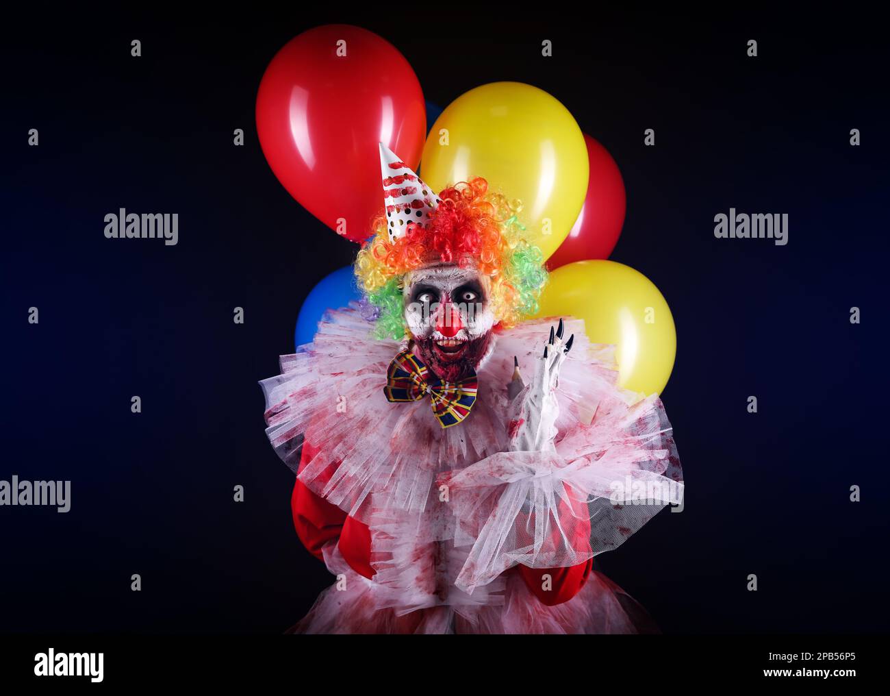 Terrifying clown with air balloons on dark background. Halloween party ...