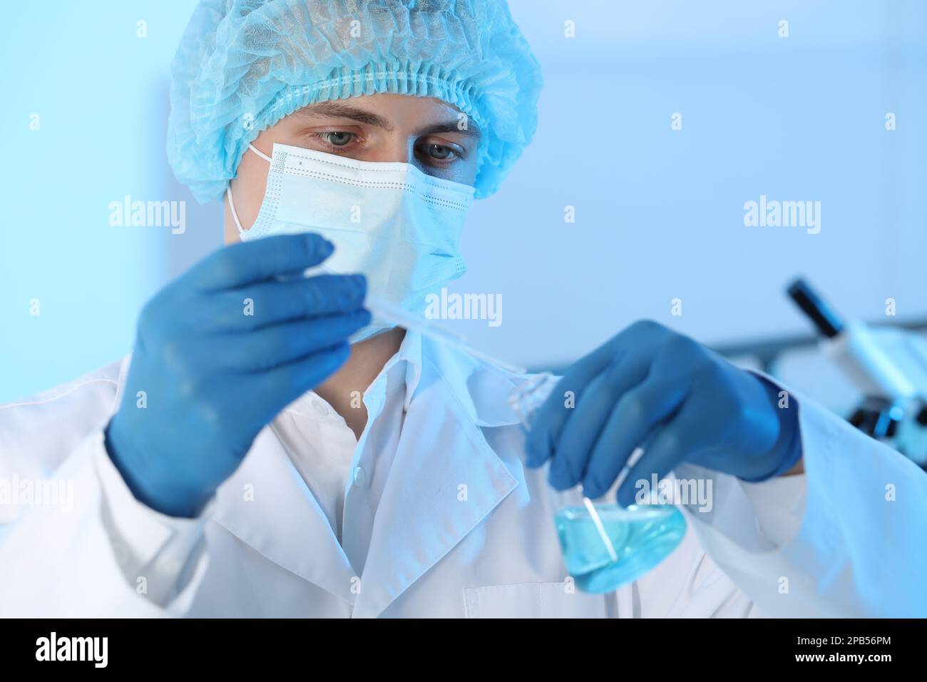 Scientist dripping sample into flask in laboratory. Medical research ...