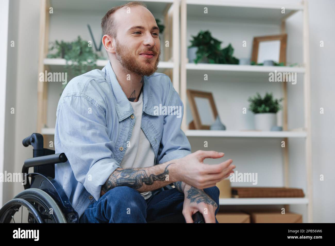A man in a wheelchair gamer plays games with a joystick in his hands at ...
