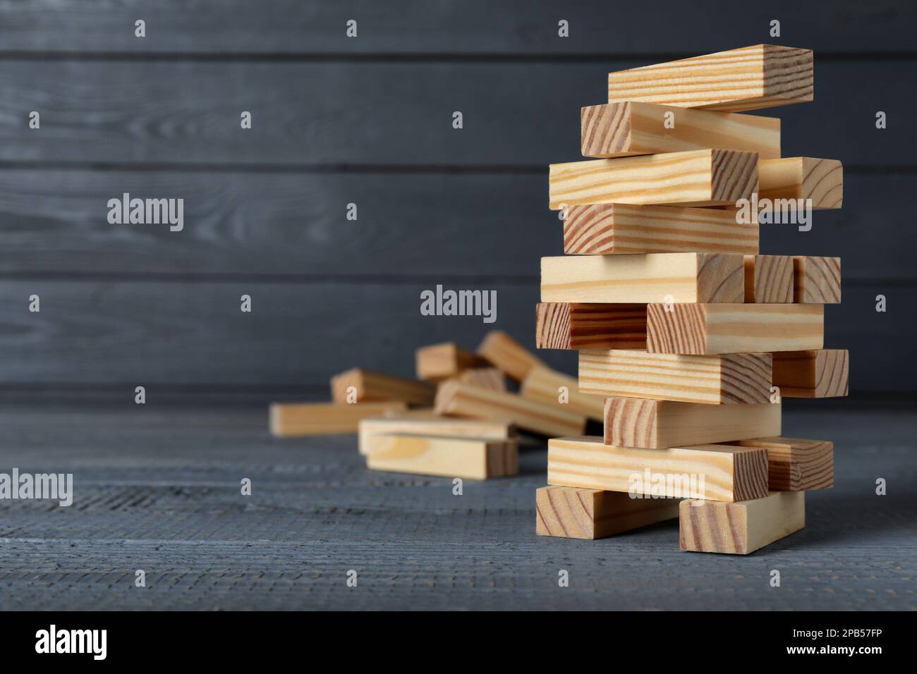 Jenga tower made of wooden blocks on grey table, space for text Stock ...