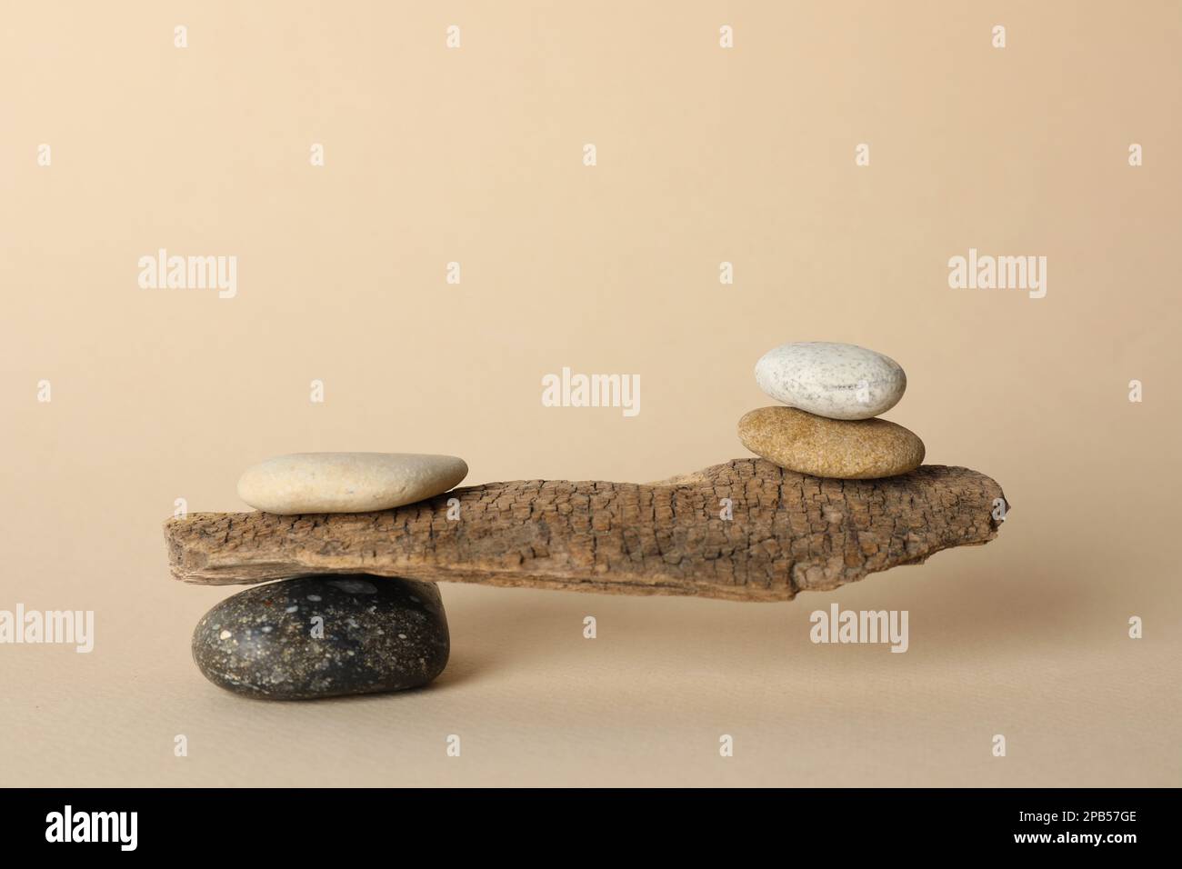 Tree branch with stones on beige background. Harmony and balance ...