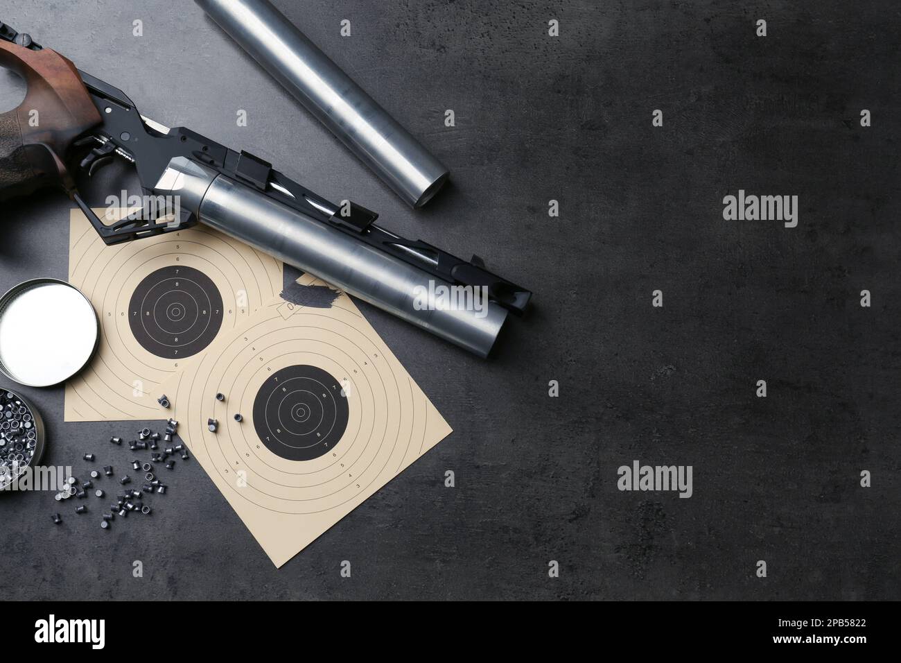 Flat lay composition with sport pistol on black table, space for text ...