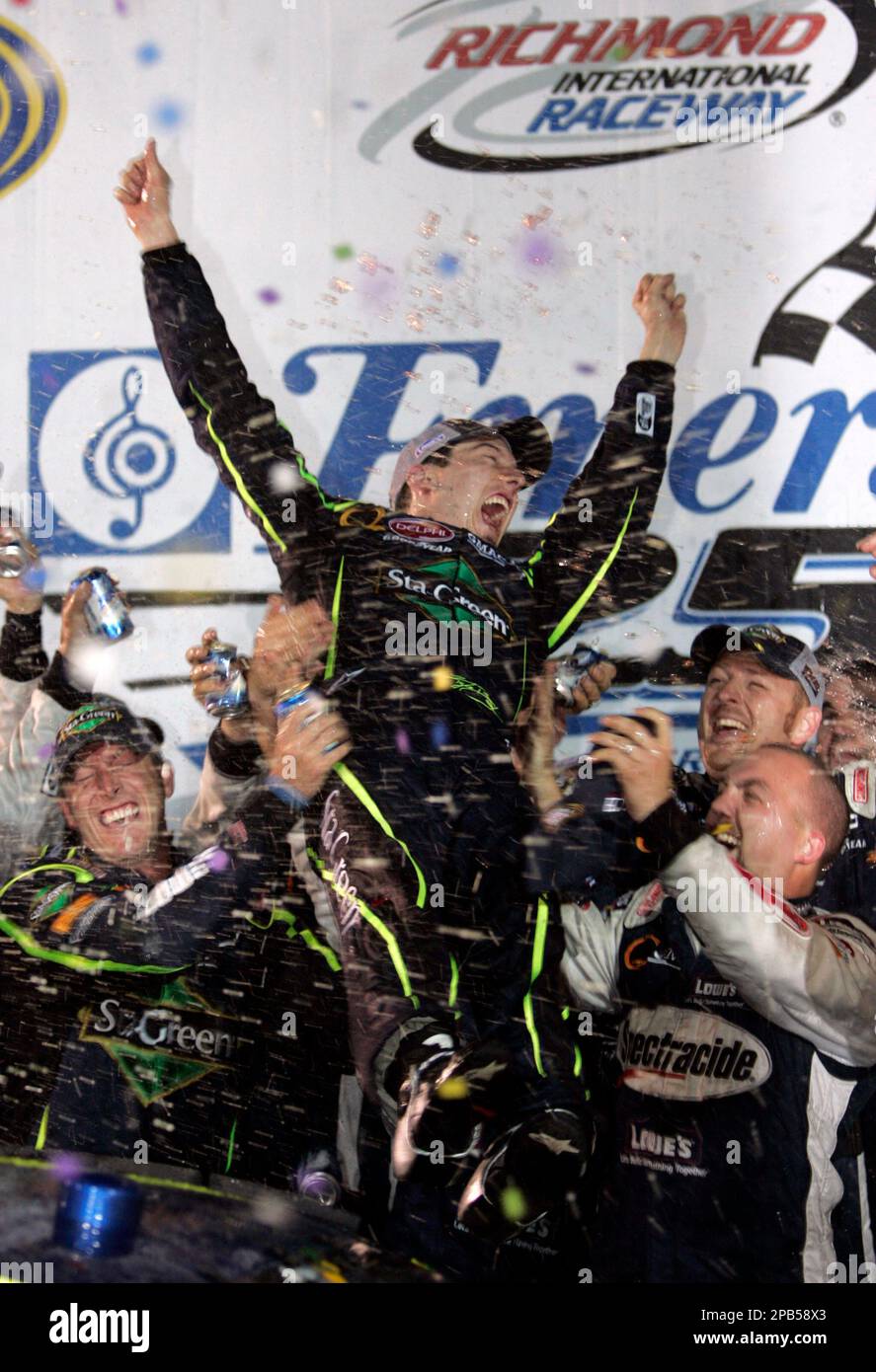 Kyle Busch, top, jumps into the arms of his pit crew as he celebrates ...