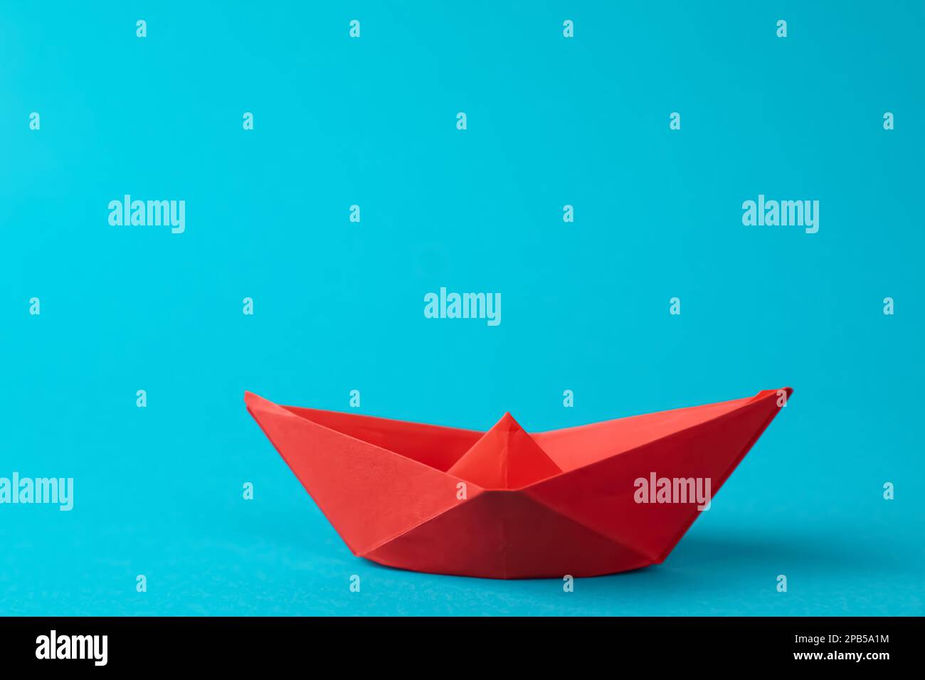 Handmade red paper boat on light blue background. Origami art Stock ...