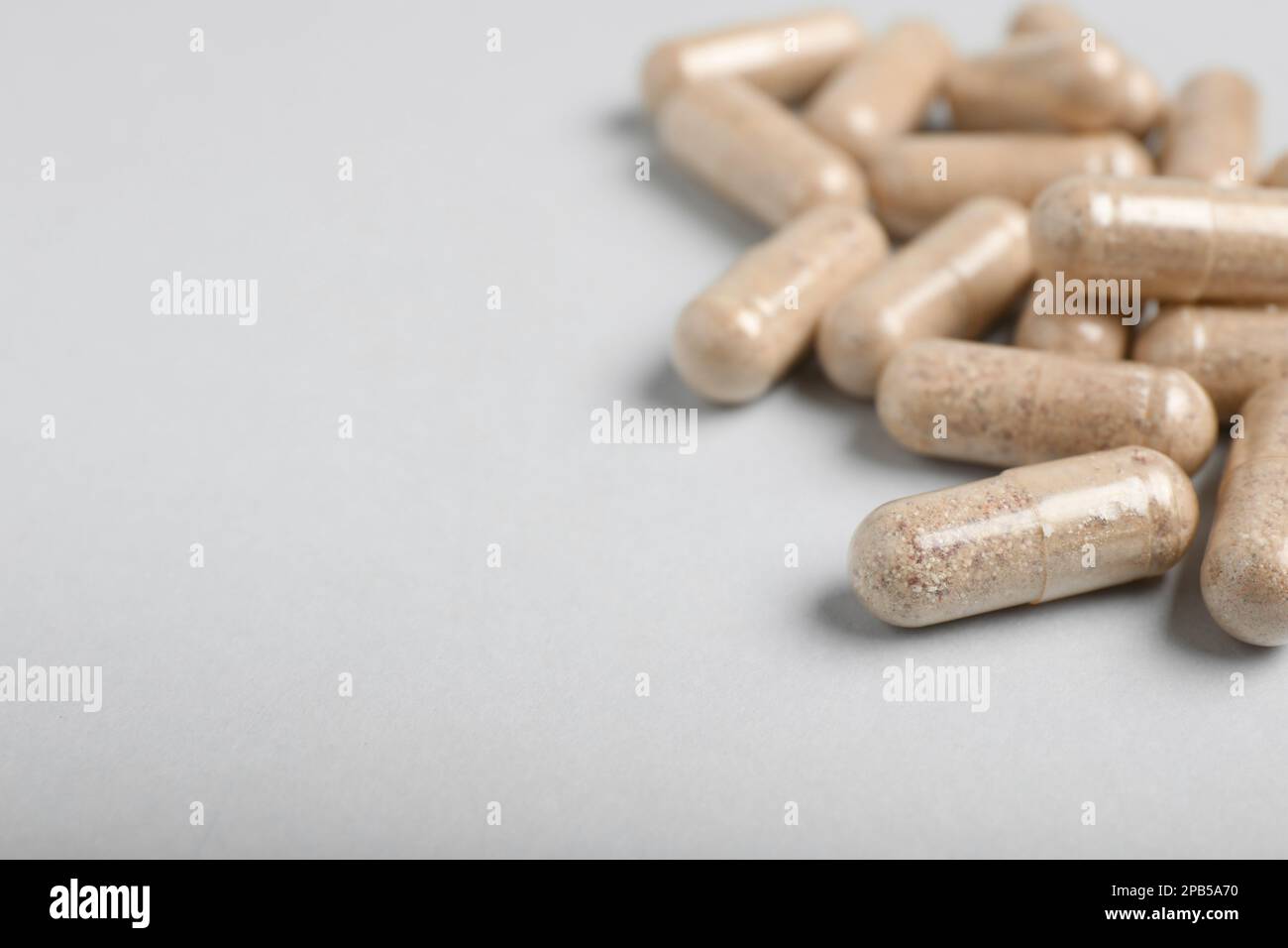 Many transparent gelatin capsules on light grey background, closeup ...