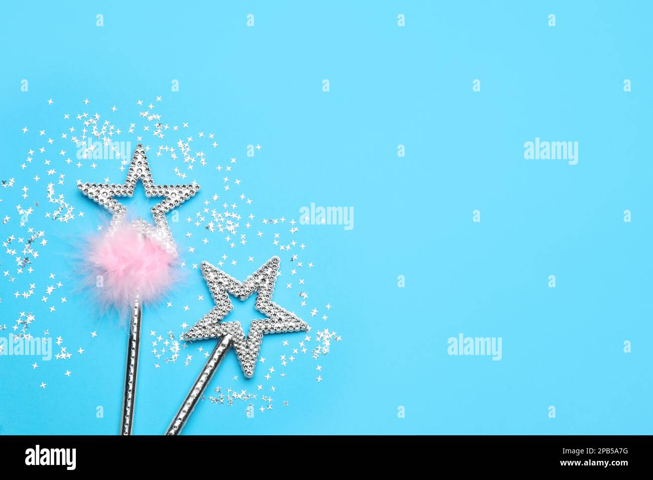 Beautiful silver magic wands and confetti on light blue background ...
