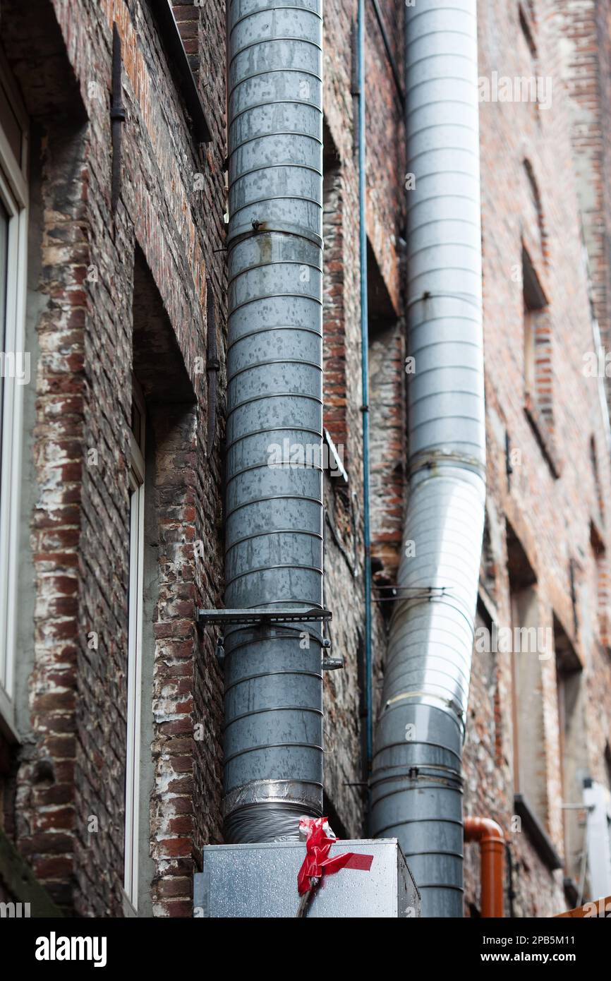 picture of ventilation pipes on the outside wall of an old brick ...