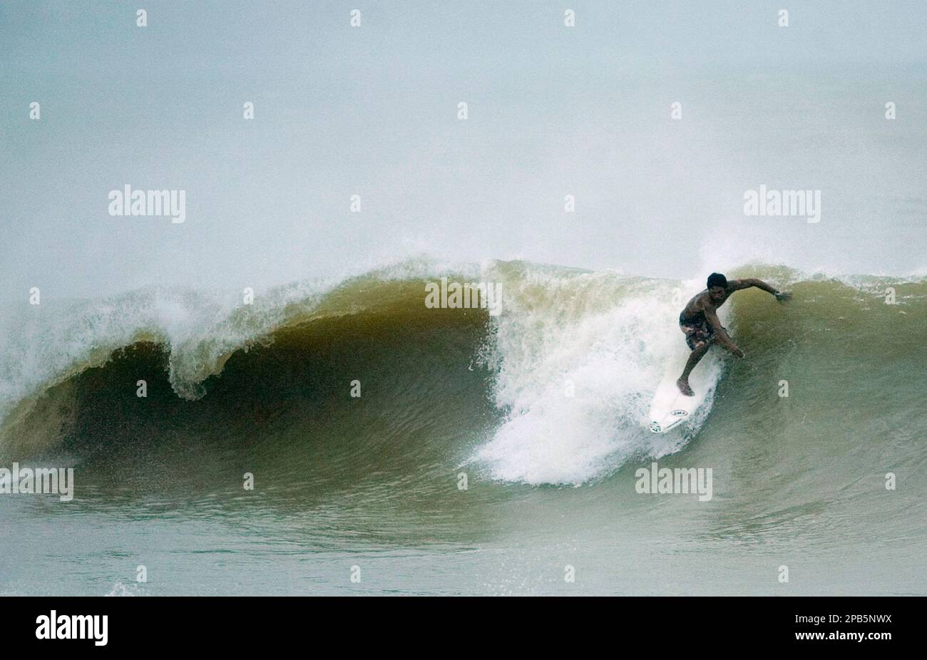 A surfer rides a wave stirred up by Hurricane Henriette in the Pacific ...