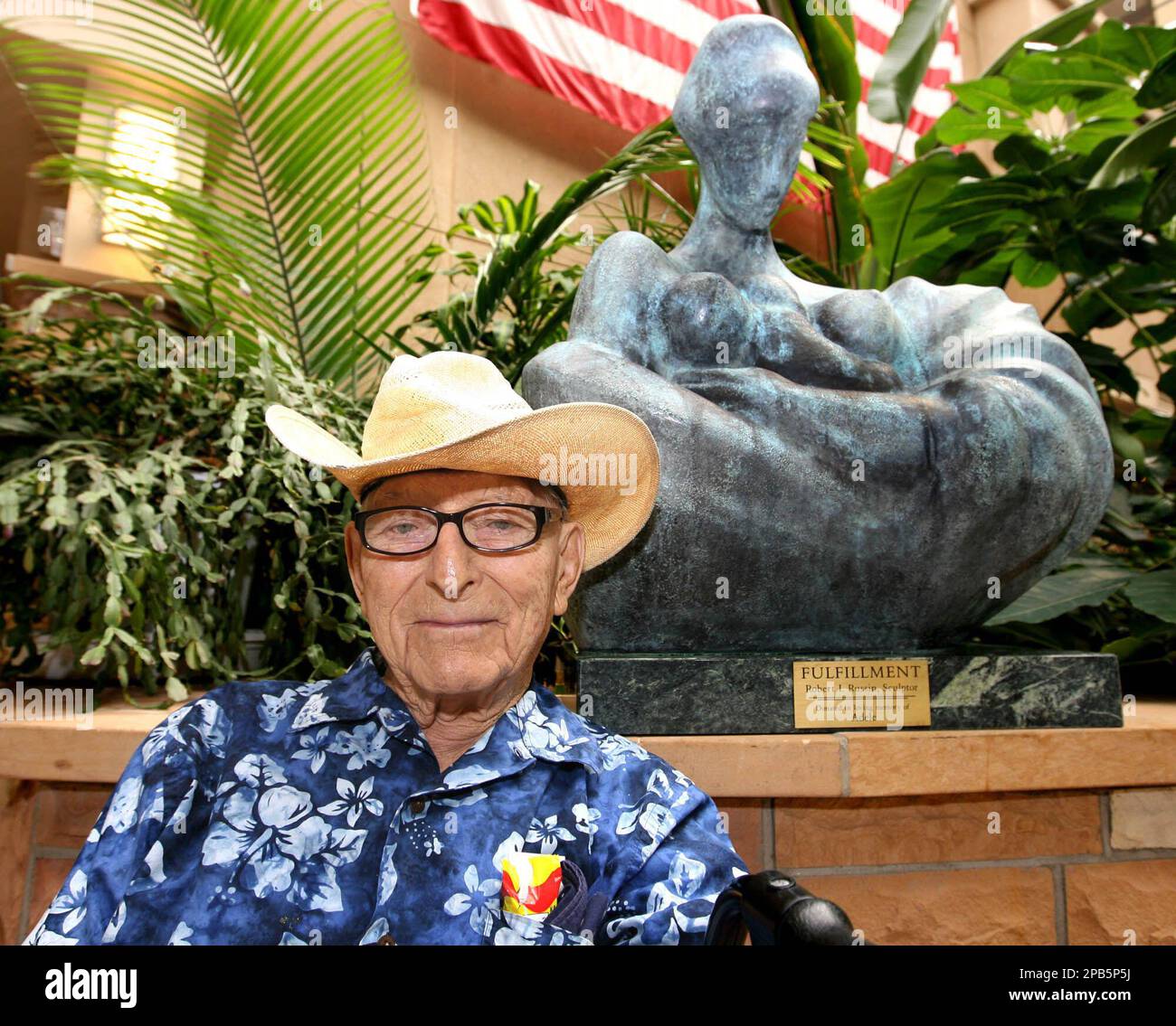Sculptor Robert Russin sits in front of his sculpture named ...