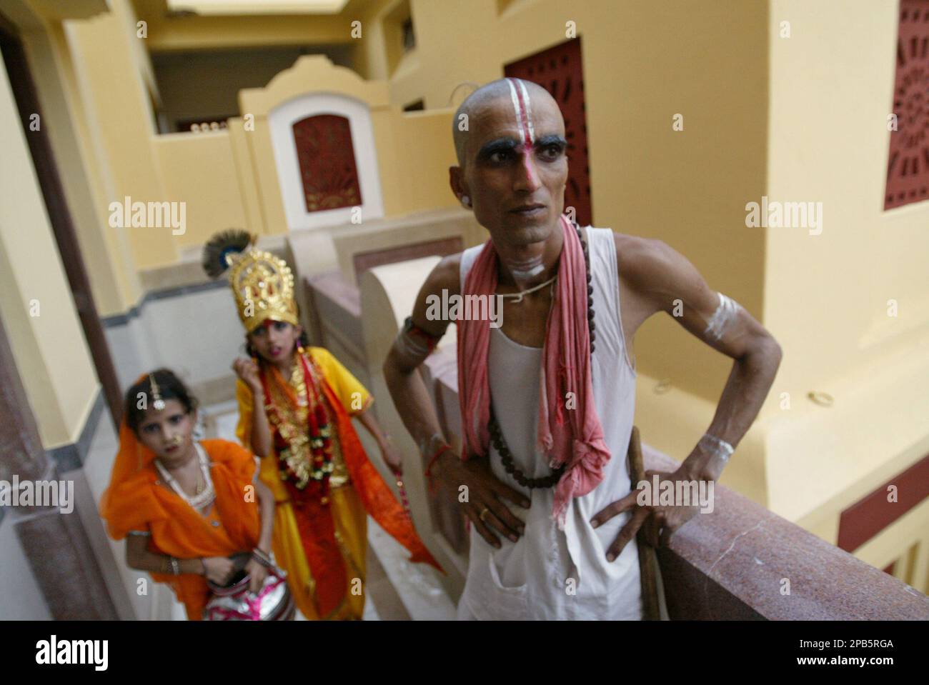 A Hindu devotee stands with his children, dressed up as the Hindu Gods ...