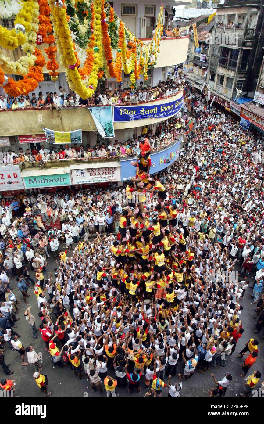 Hindu devotees form a human pyramid to break the "Dahi handi", an ...
