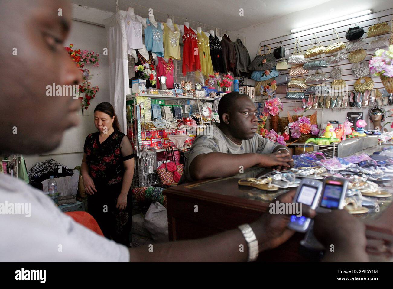 Senegalese shop assistants wait for clients under the watch of the ...