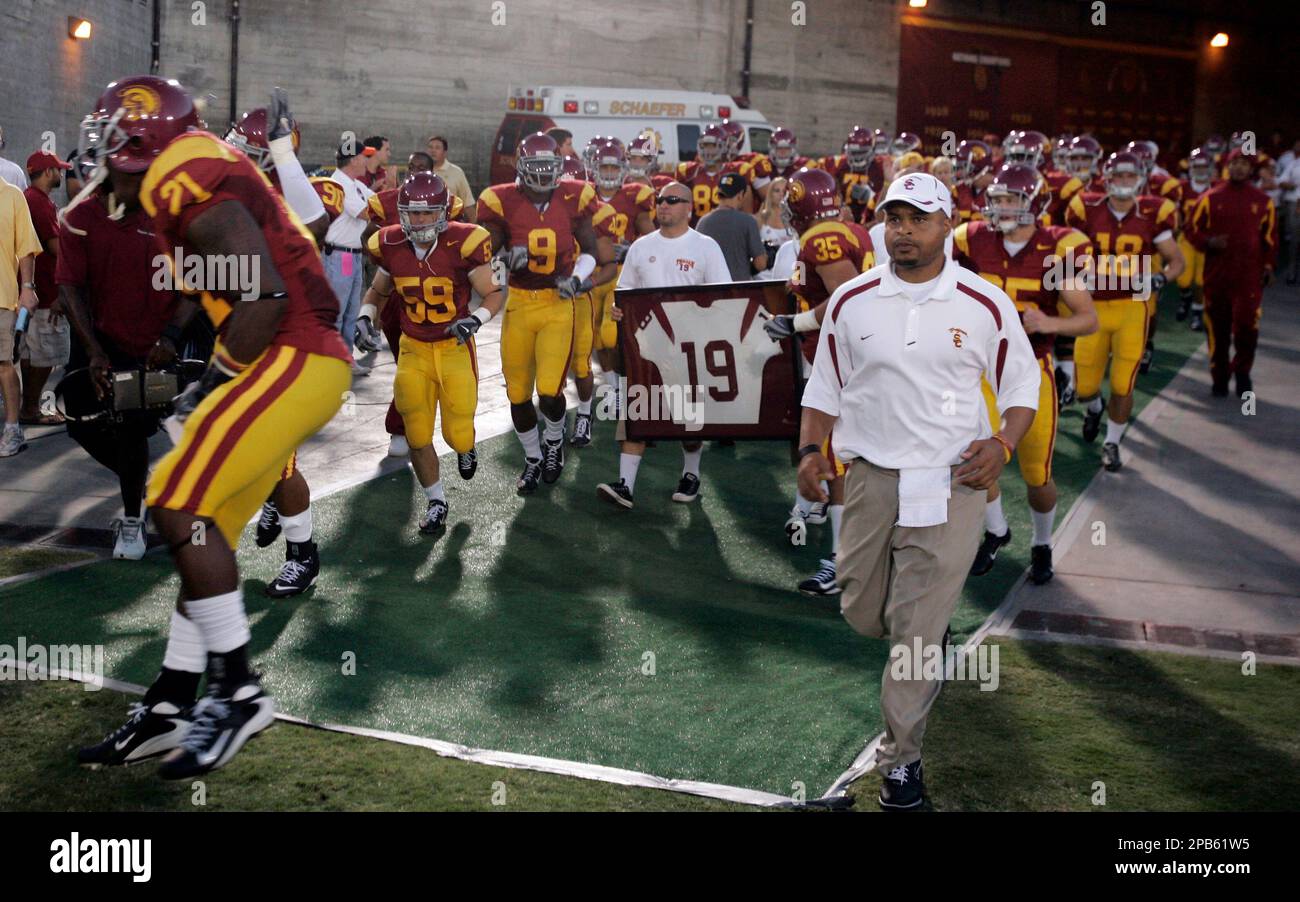 Southern California team members run onto to the field, some carrying a ...