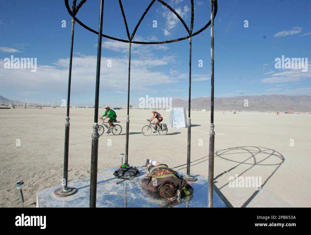 A Burning Man festival participant rests in an art piece on the playa ...