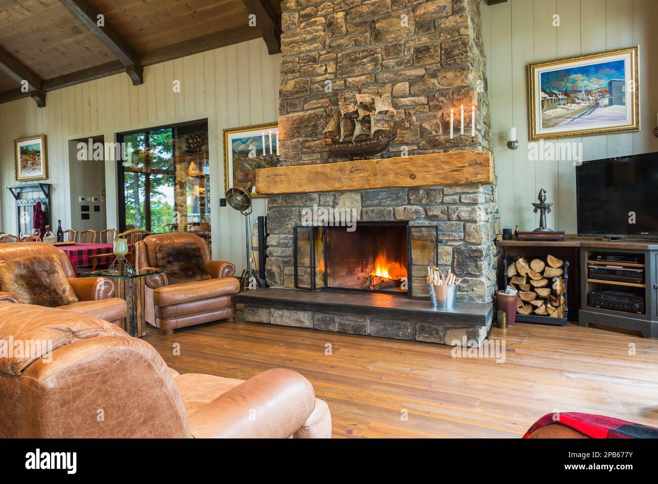 Tan leather sofa and armchairs, natural cut stone fireplace in living ...