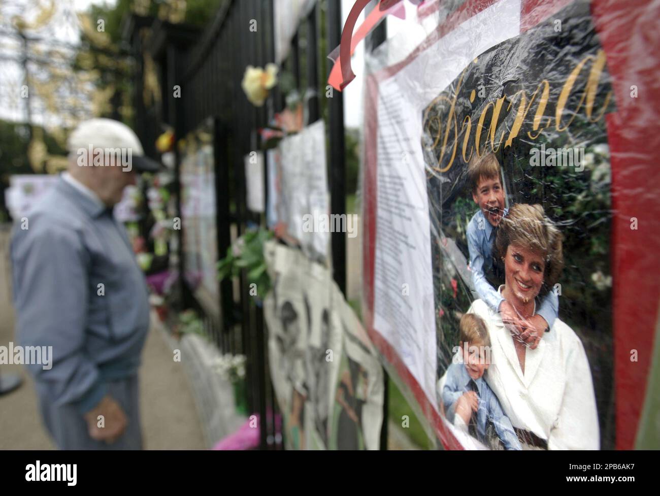 Edward Larkin, left, looks as photographs, notes, and flowers are ...