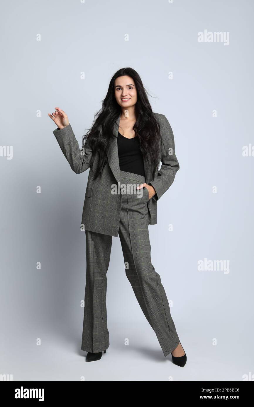 Full length portrait of beautiful woman in formal suit on light ...