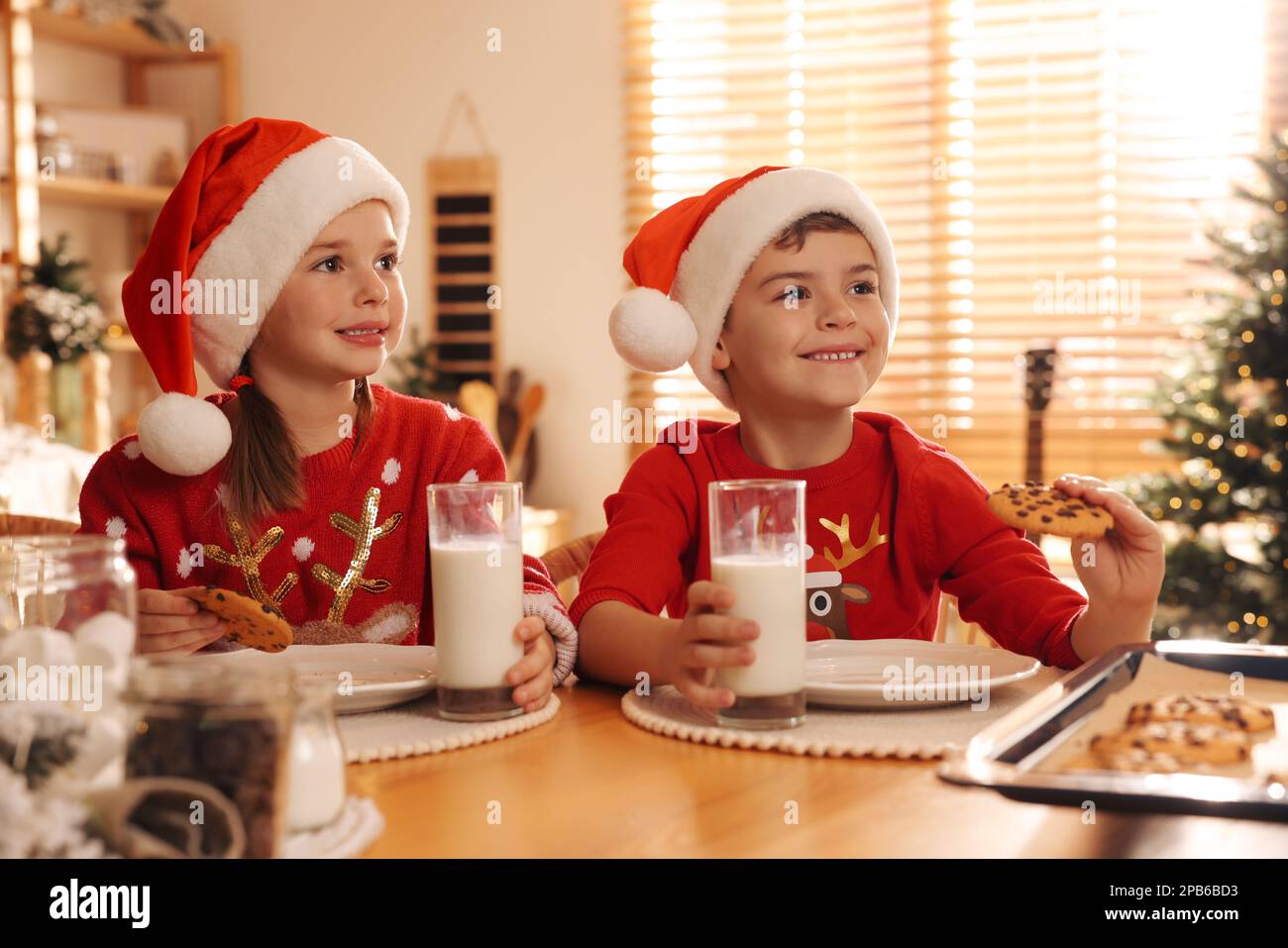 Cute little children eating delicious Christmas cookies at home Stock ...
