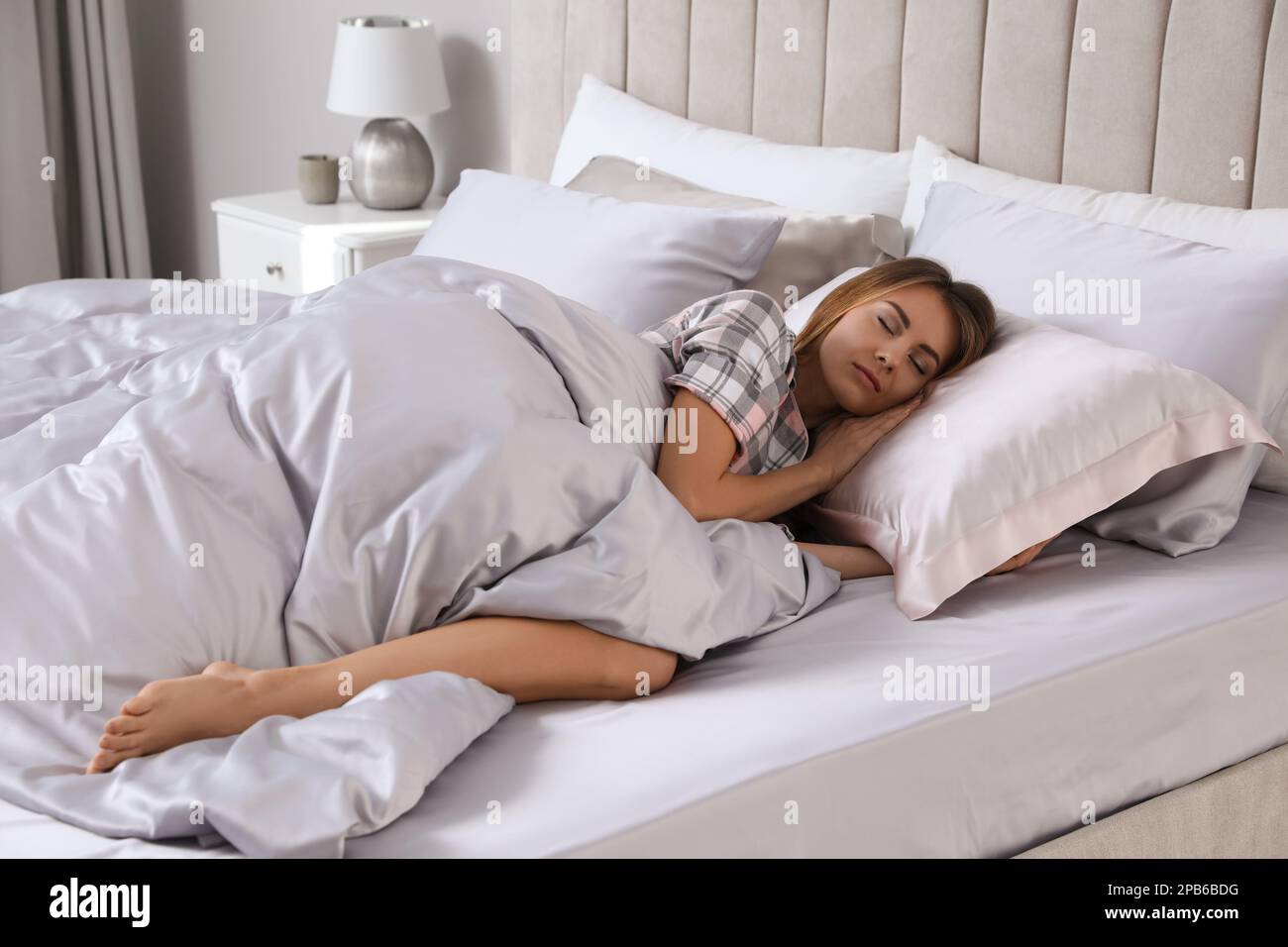 Beautiful woman sleeping in comfortable bed with silky linens Stock ...