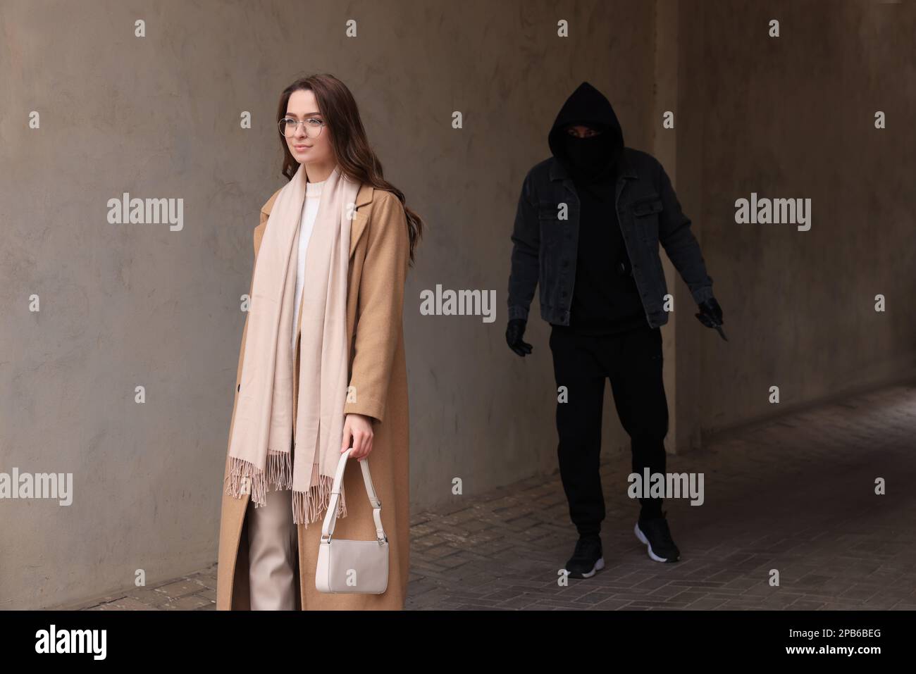 Man with knife stalking young woman in alley Stock Photo - Alamy
