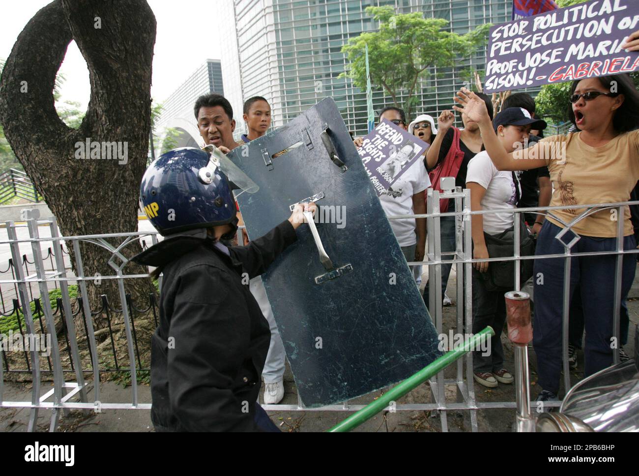 A female riot police hits protesters with her baton as the latter are ...
