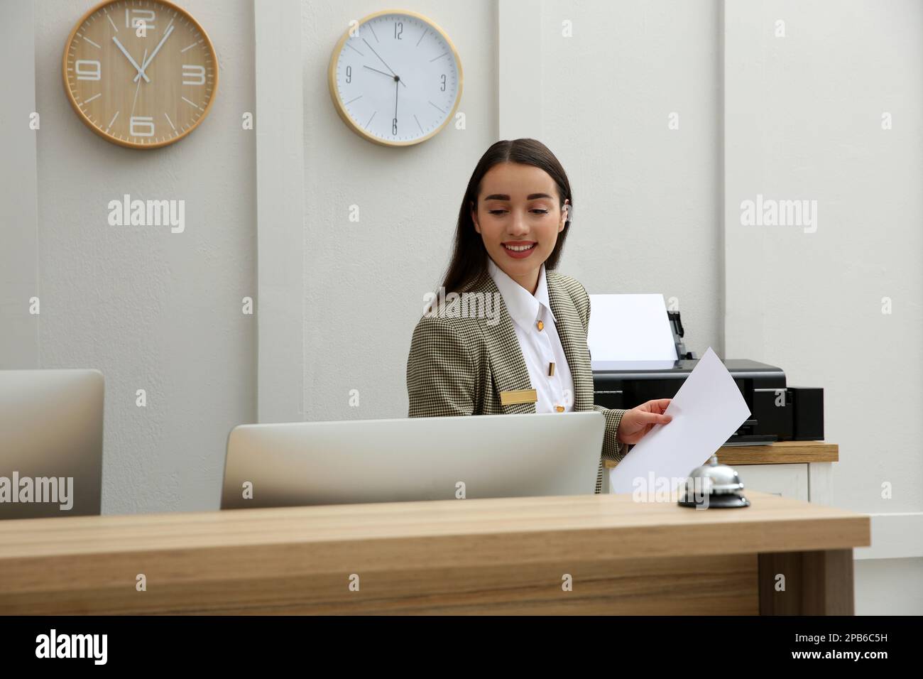 Beautiful receptionist working at counter in hotel Stock Photo - Alamy