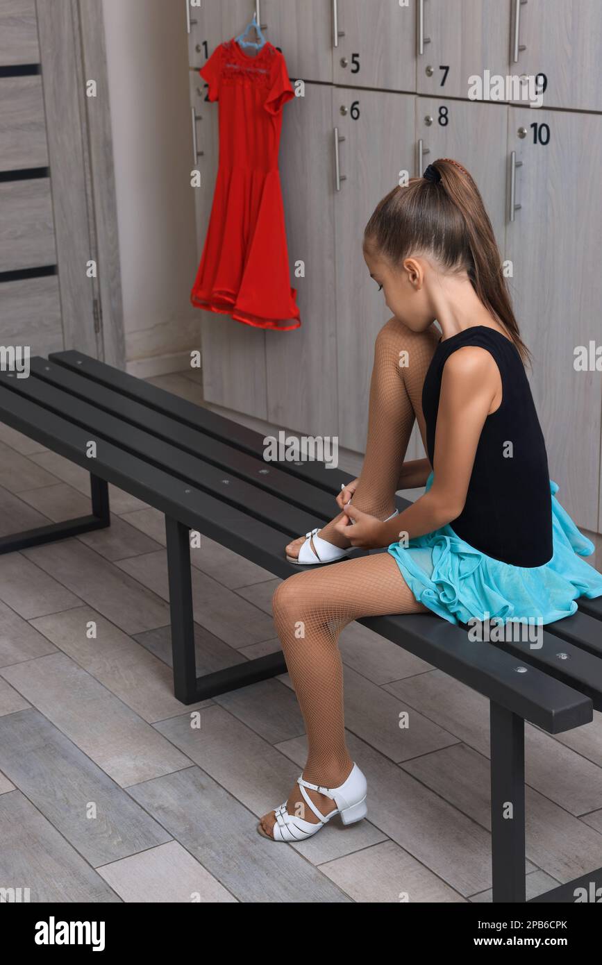Little girl putting on shoes in locker room Stock Photo - Alamy