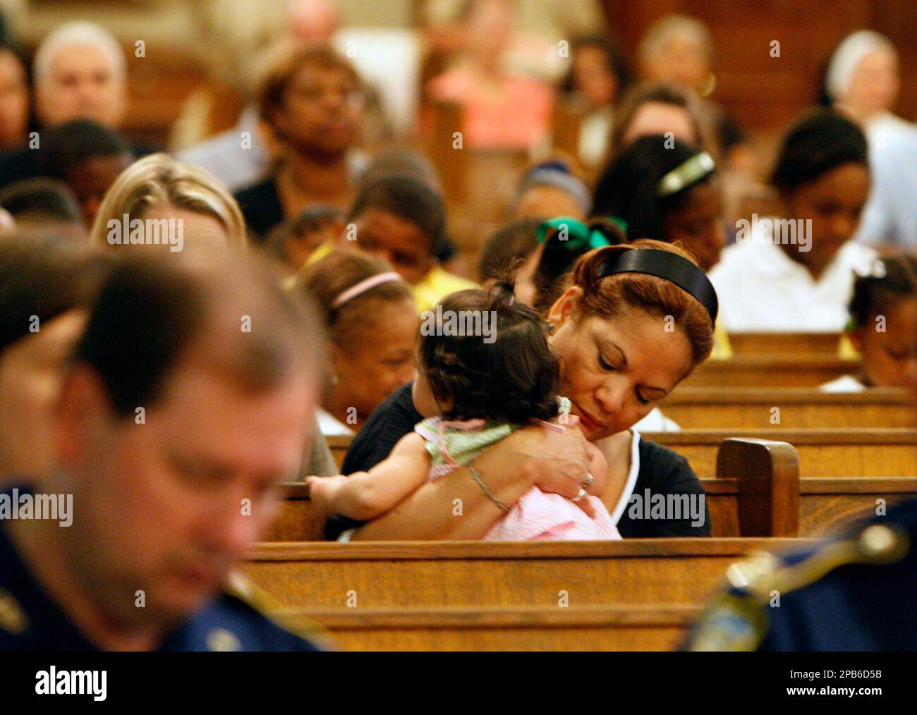 Maria Nelson holds her daughter, Meredith, as she attends a service ...