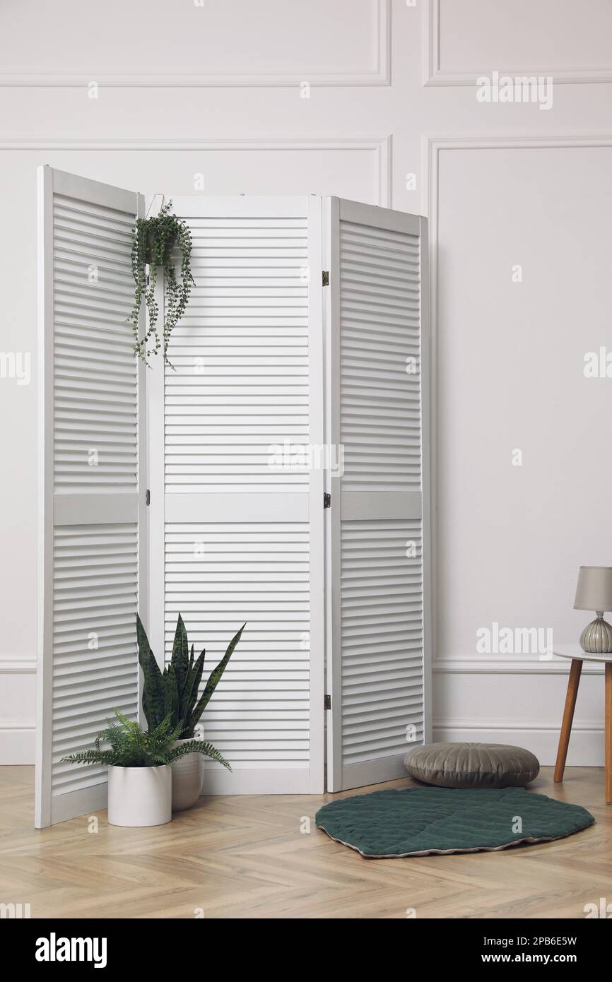 Stylish room with folding screen and floral decor. Interior design ...