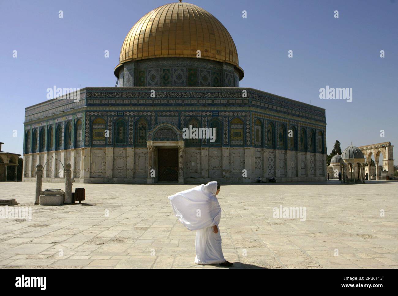 A Muslim girl walks by the Golden Dome of the Rock mosque in the Al ...