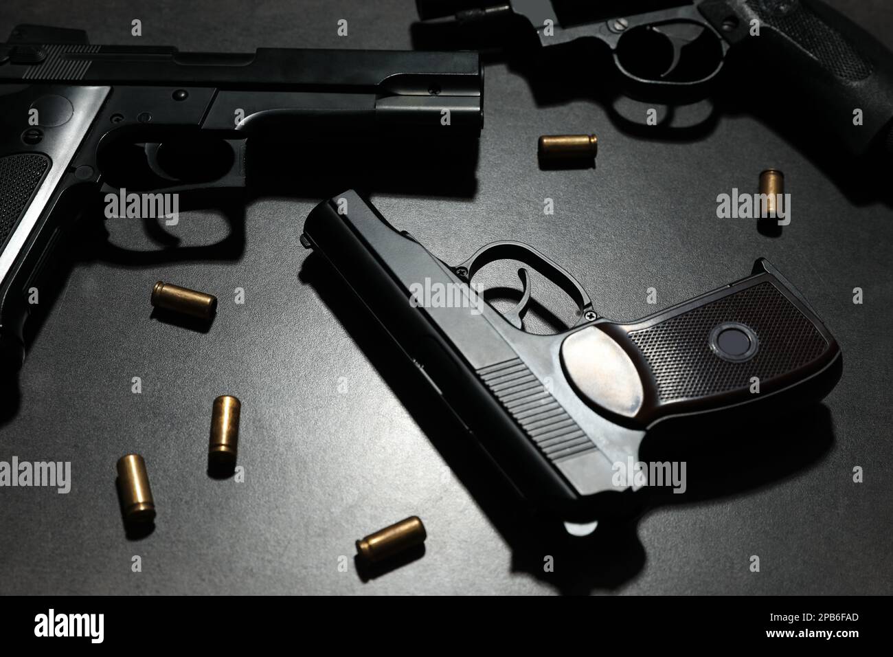 Different guns and bullets on grey table Stock Photo - Alamy