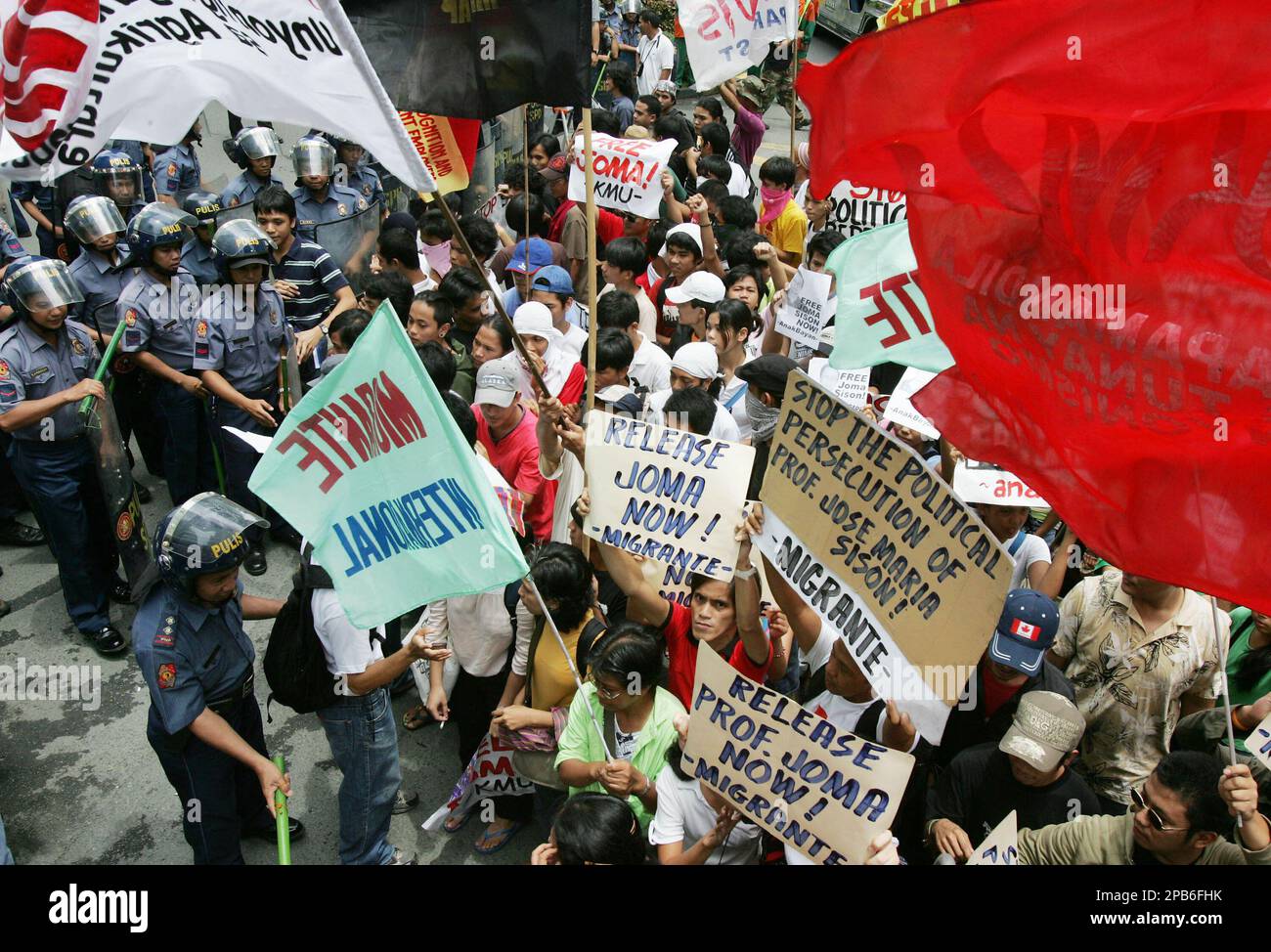 Riot police try to clear a portion of the street as militant youths ...