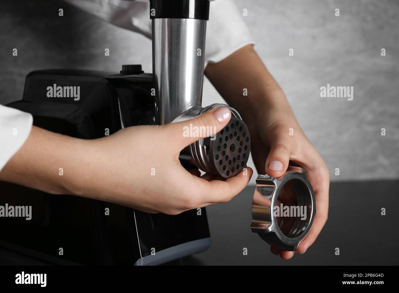 Woman assembling electric meat grinder at black table, closeup Stock ...