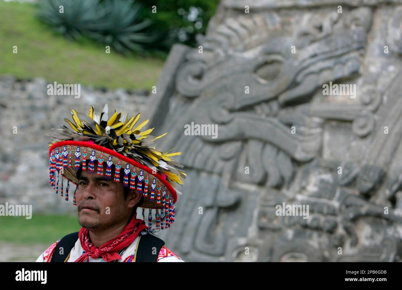 An indigenous dressed in traditional costumes looks on during a ...