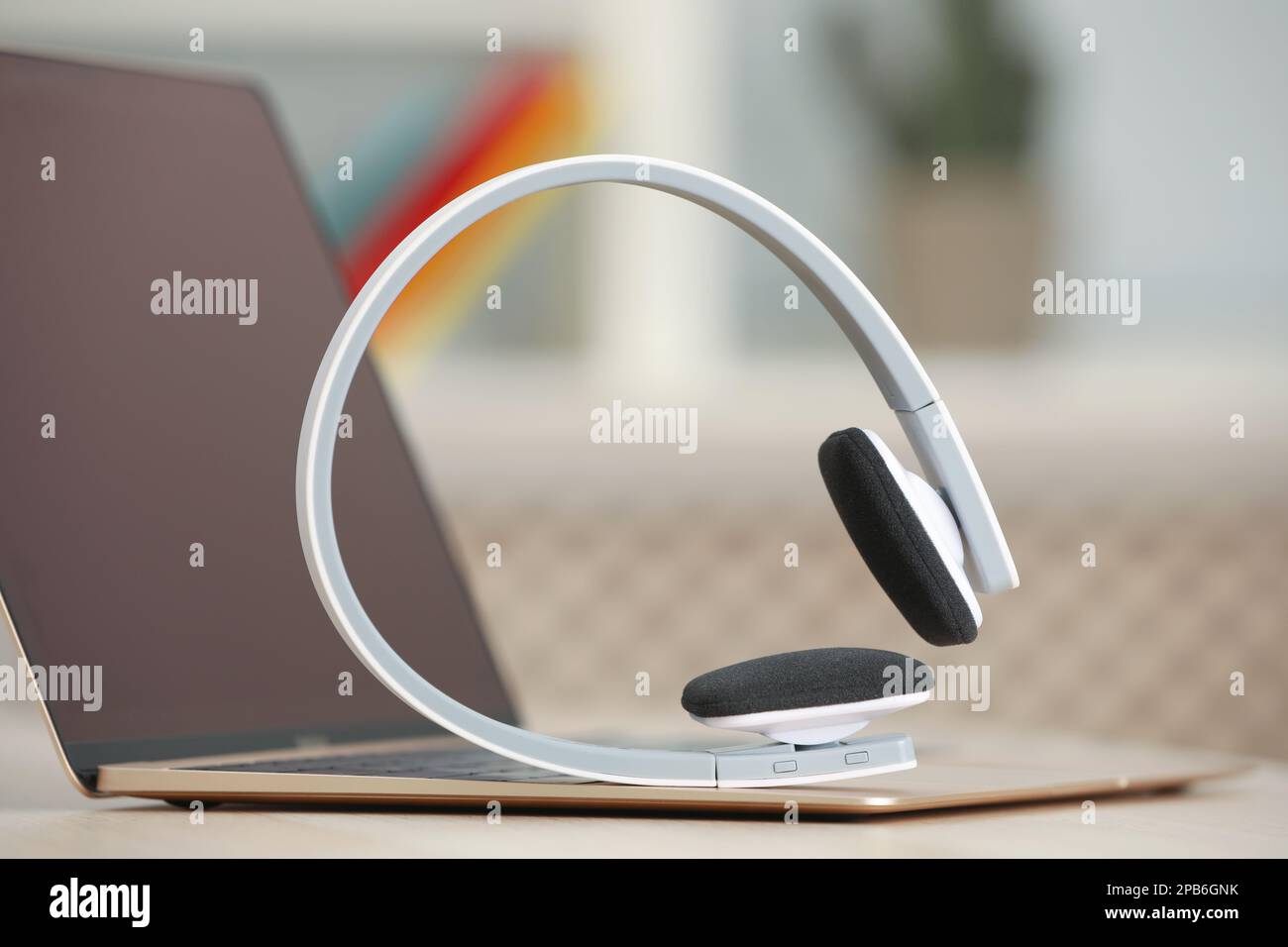 Modern headphones and laptop on table indoors Stock Photo - Alamy
