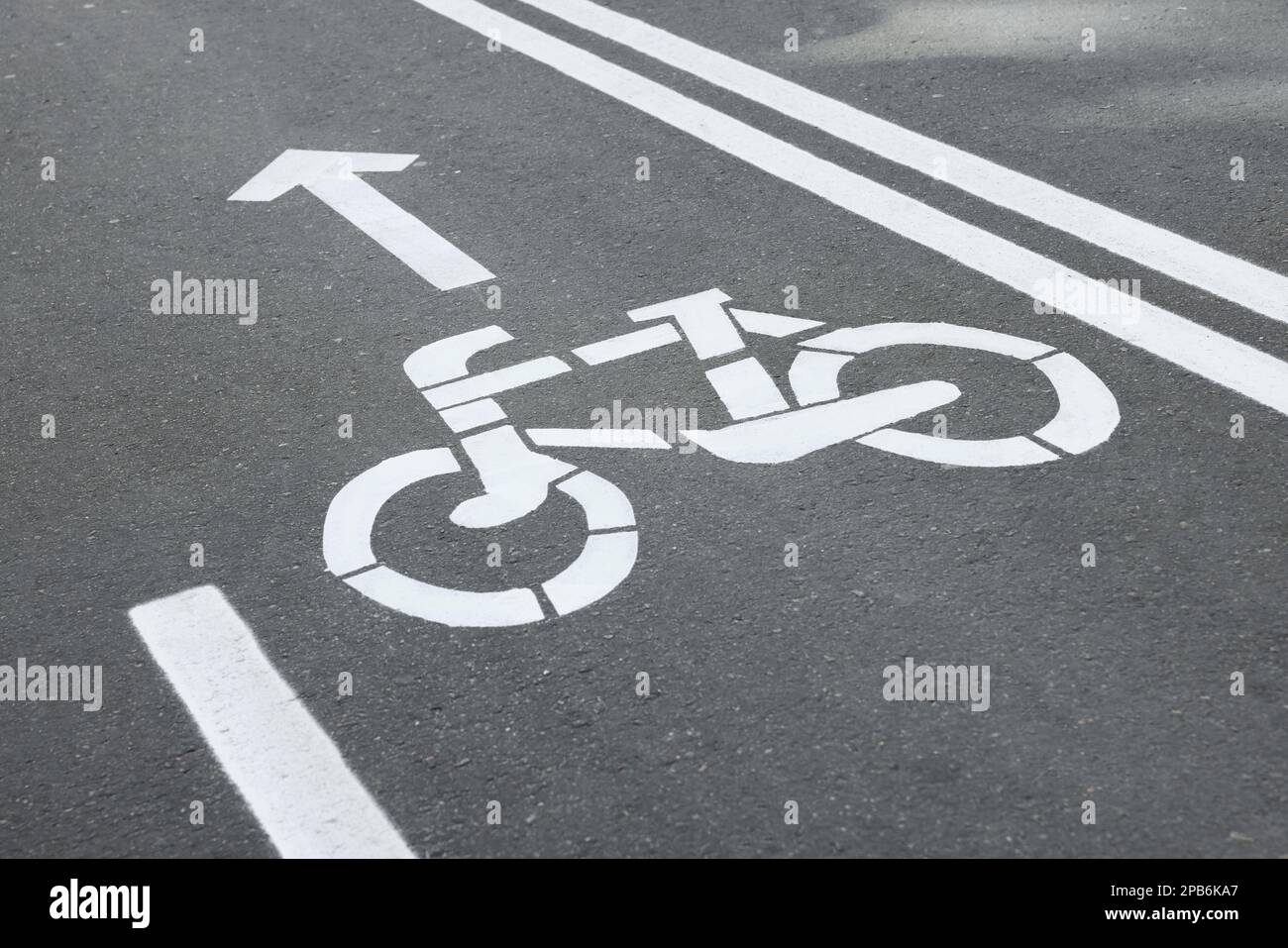 Bicycle lane with sign and arrow pointing direction on asphalt, closeup ...