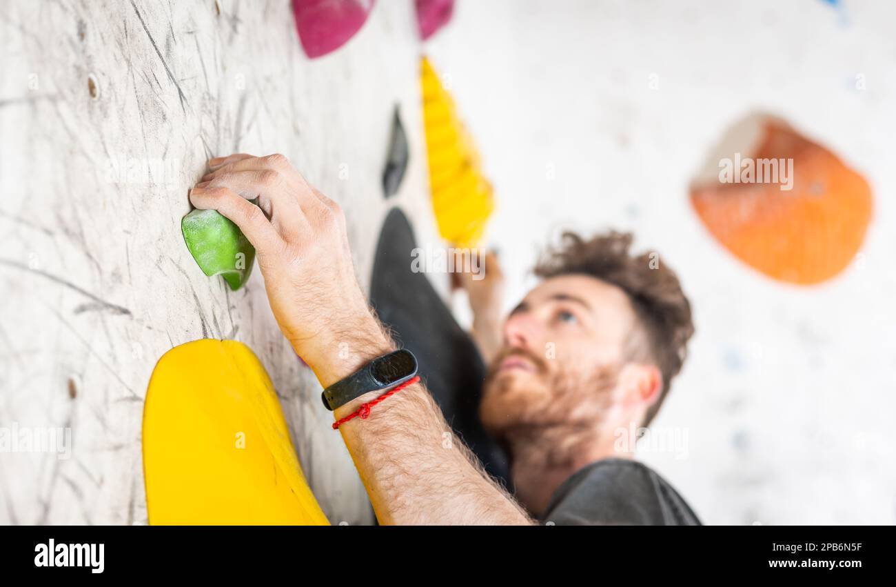Young climber climbing on the boulder wall indoor, rear view, concept ...