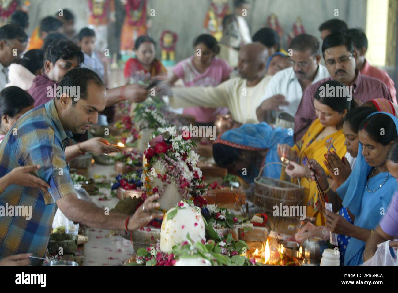 Indian Hindu devotees offer prayers to a row of Shivlings, idols ...