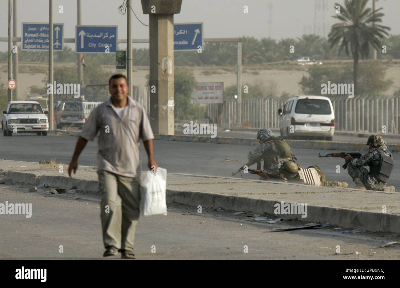 A man passes by as members of the joint Iraqi security forces take ...