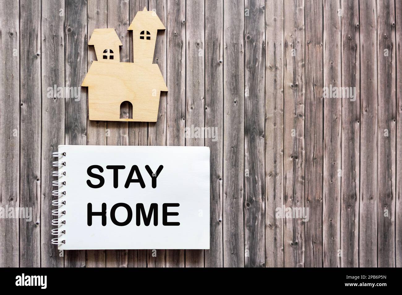 STAY HOME text on notepad with wooden home symbol .Banner to promote ...