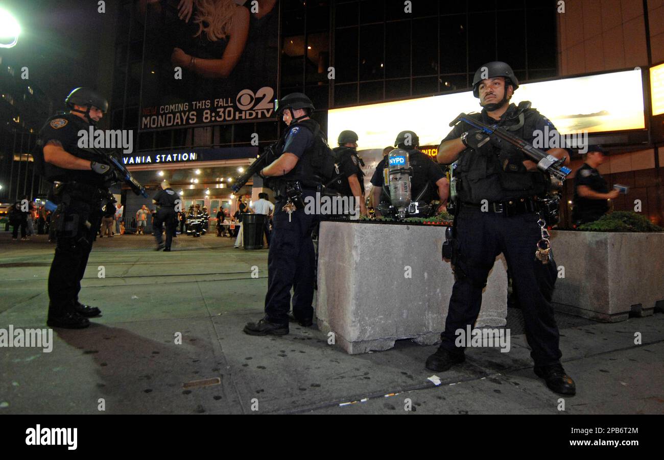 Heavily armed members of the Hercules Unit surround an entrance to ...