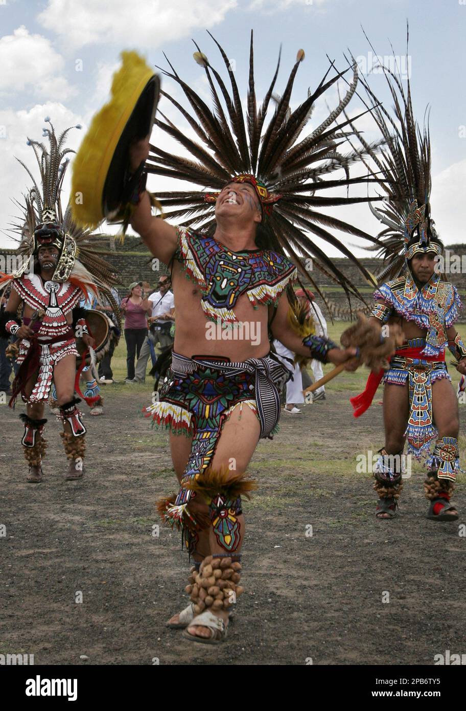 Mexican Azteca indigenous men, dressed in traditional costumes, dance ...